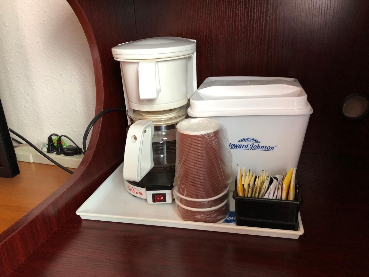 Uma cafeteira, um jarro de café, um recipiente para café e uma bandeja com utensílios.
