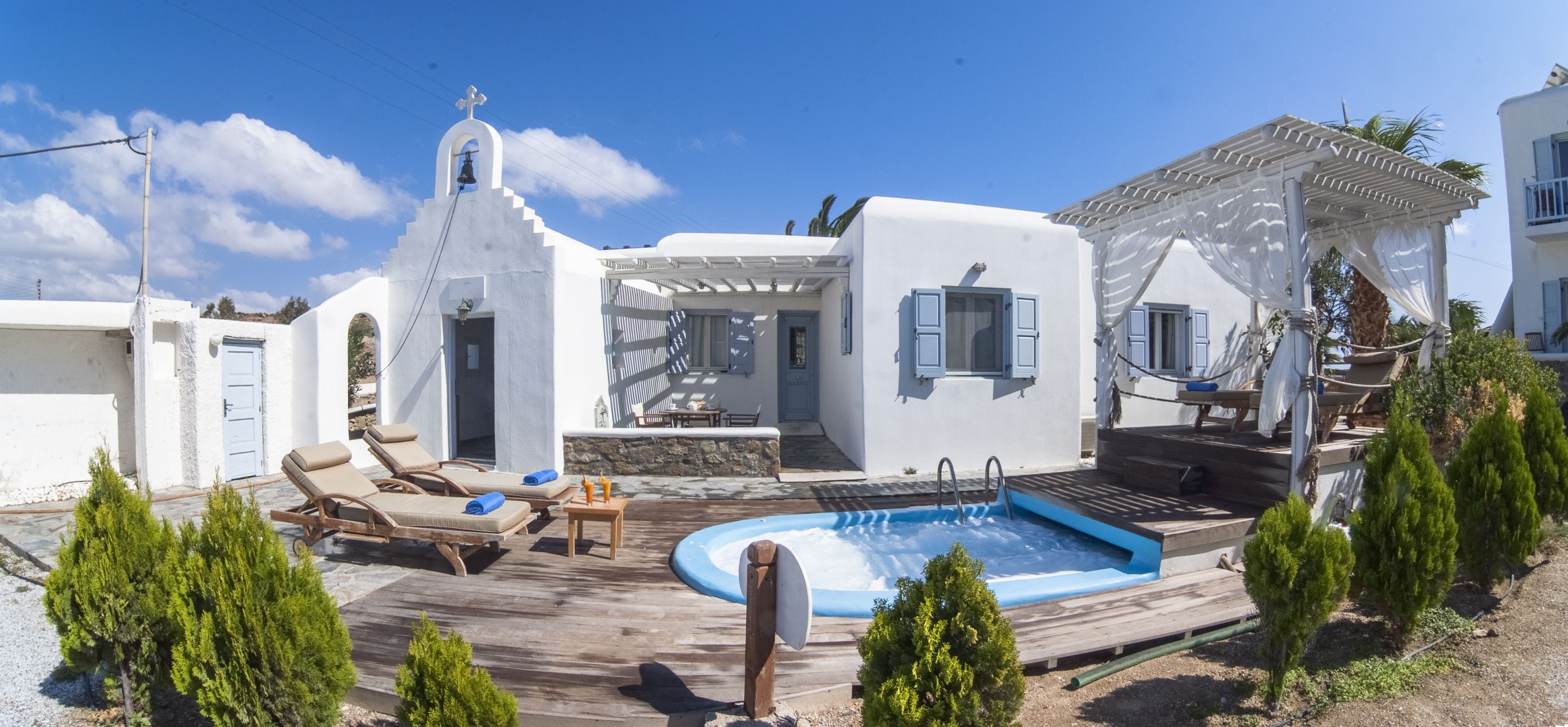 Uma villa branca com piscina, área de estar ao ar livre e pérgola.