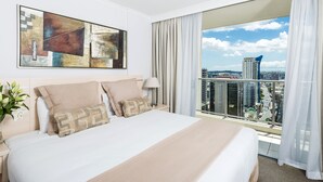 Quarto de hotel com uma cama grande, vista da cidade e arte abstrata na parede.