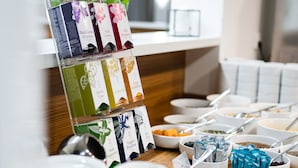 Disposição de buffet de café da manhã com diversas opções de chá e comida.