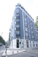 Um edifício de vários andares com fachada curva, janelas grandes e varandas.