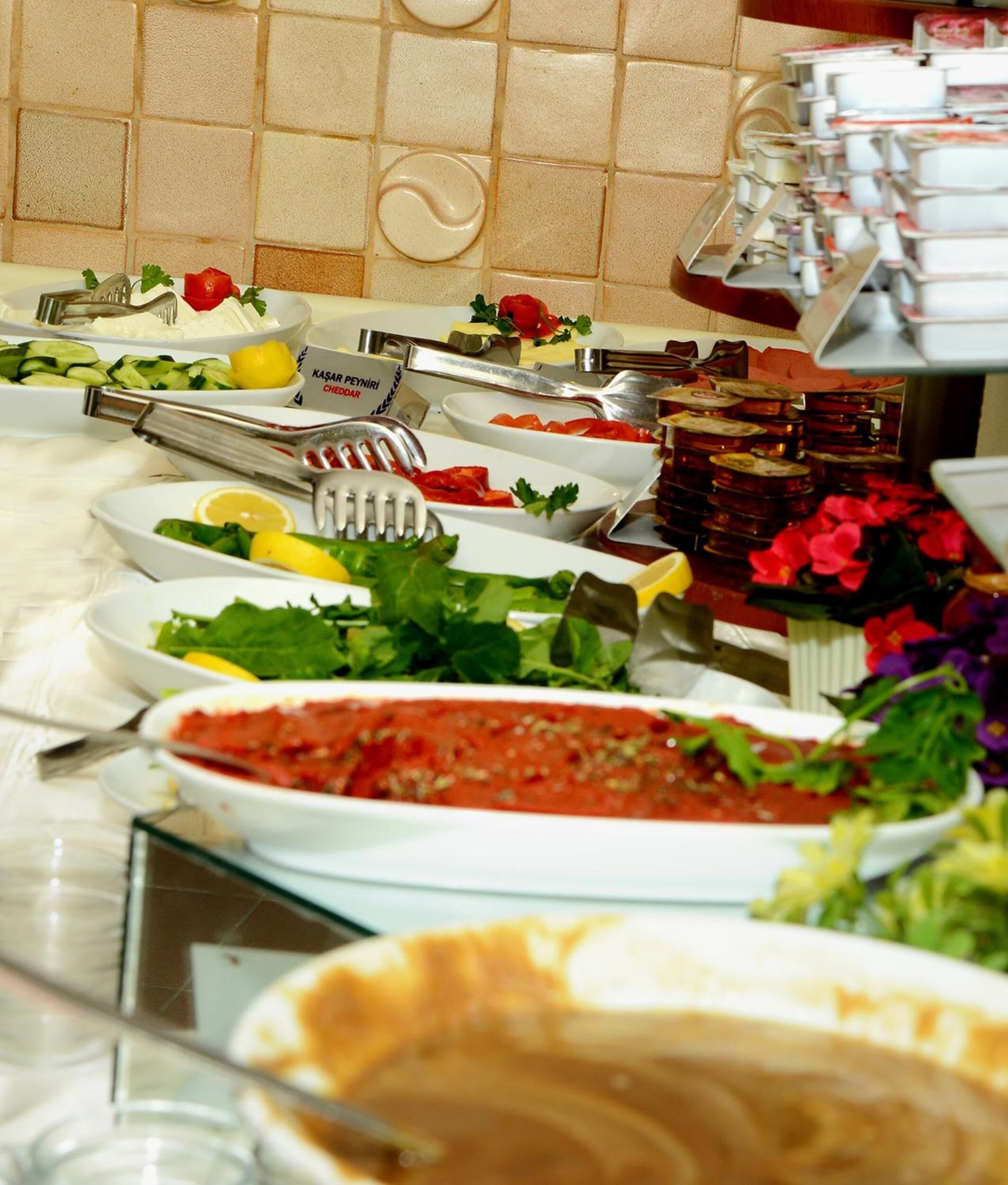 Buffet com diversos pratos, incluindo saladas, carnes e molhos.