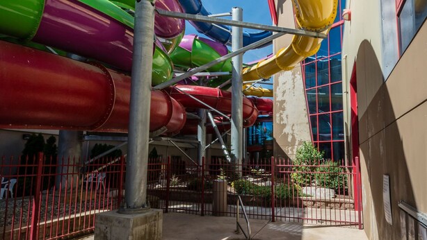 Um parque aquático com vários toboáguas coloridos e uma área de piscina.