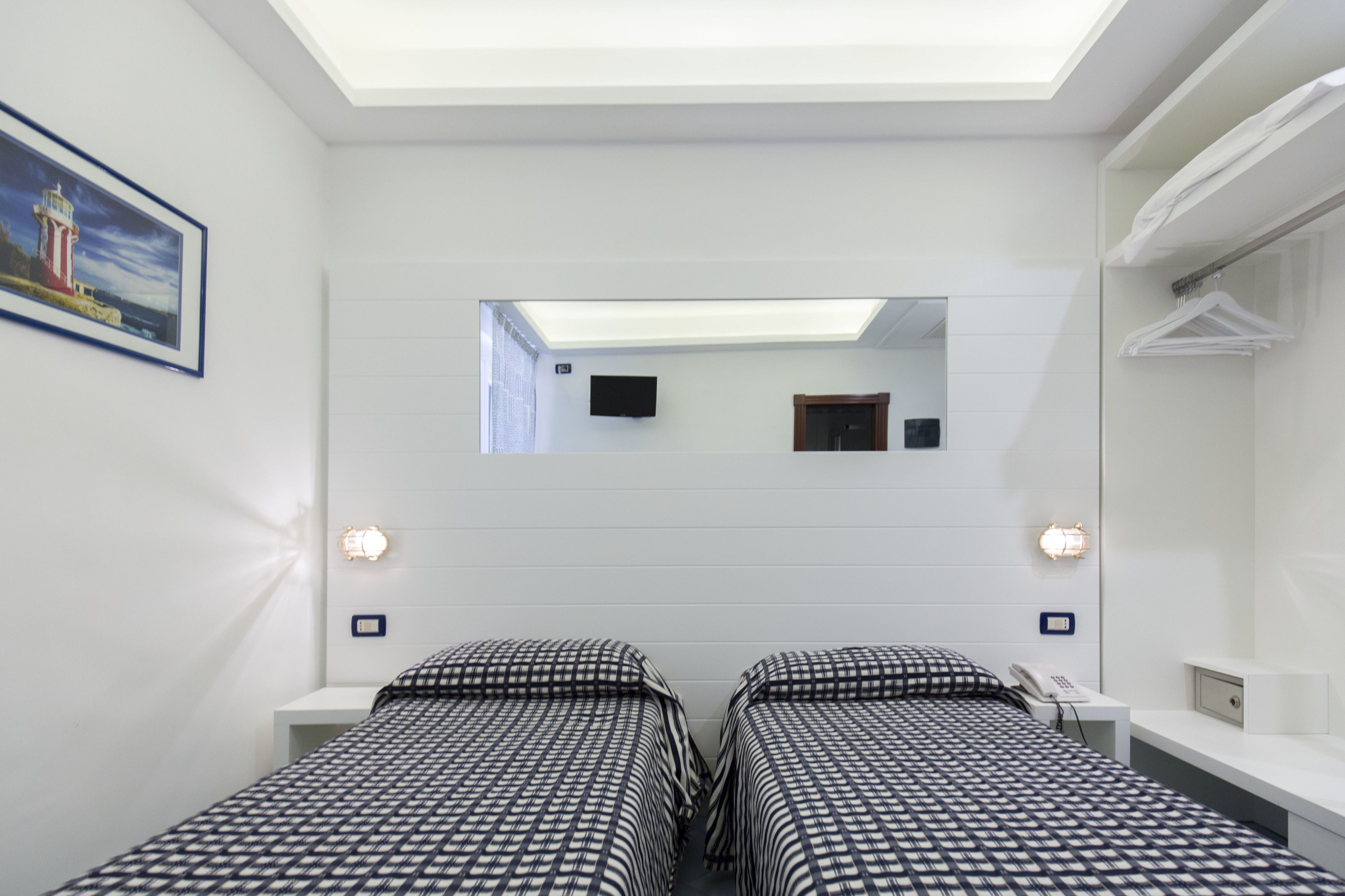 Quarto de hotel com duas camas, um claraboia, uma televisão e um espelho.