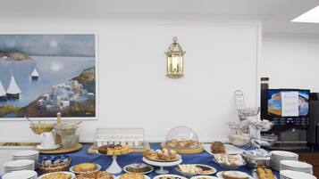 Uma mesa de buffet com diversos pastéis e uma máquina de café.