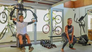 Uma academia com equipamentos de ginástica, bicicletas e pesos.