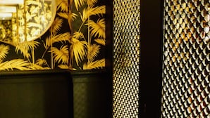 Um quarto com piso estampado, um espelho na parede e um painel texturizado.