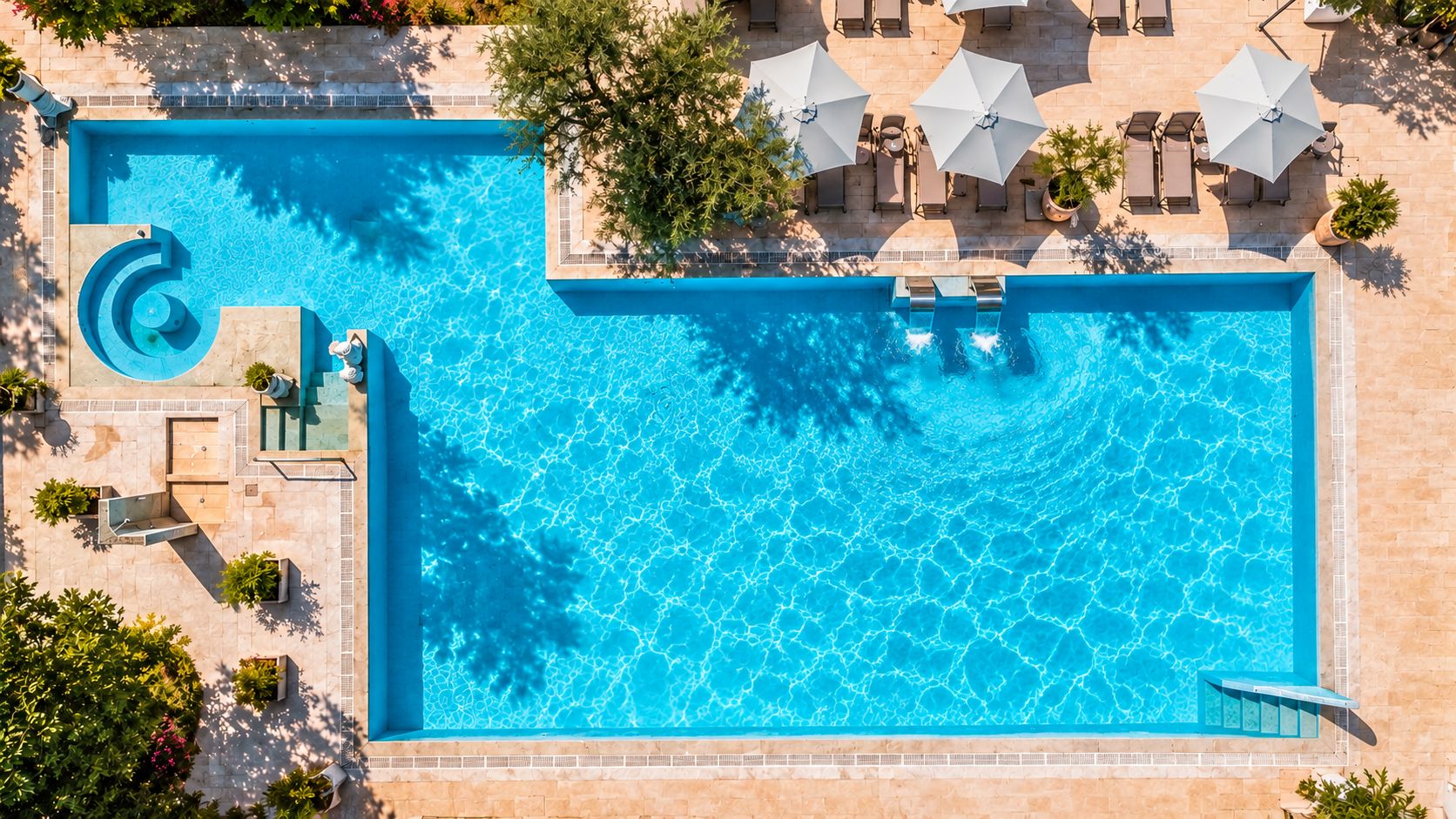 Uma piscina retangular grande com superfície de água azul cristalina, rodeada por espreguiçadeiras e guarda-sóis, e uma área circular pequena com hidromassagem.