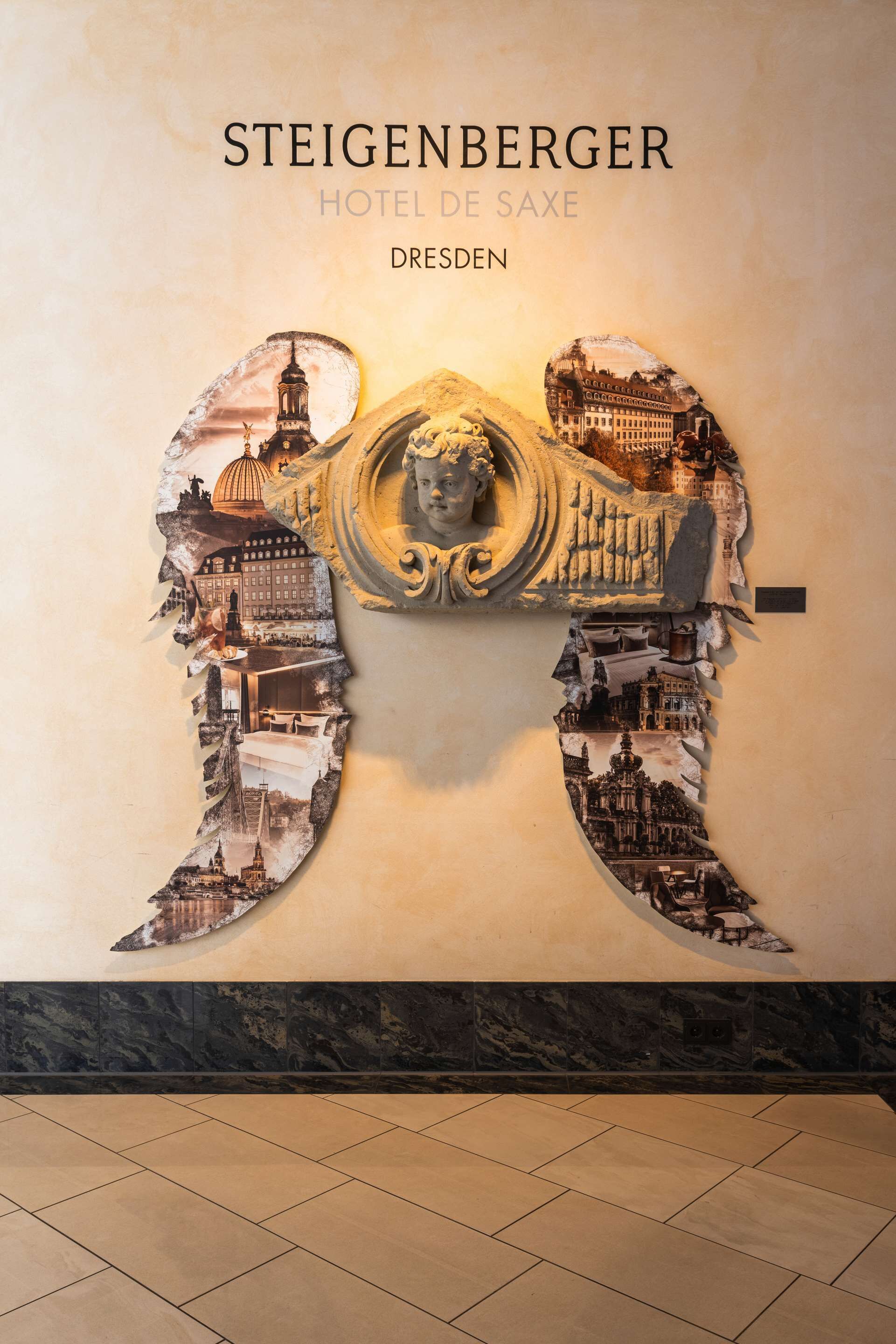 Obra de arte na parede do Hotel Steigenberger de Saxe, Dresden, com um design central ornamentado rodeado por imagens de pontos turísticos da cidade.