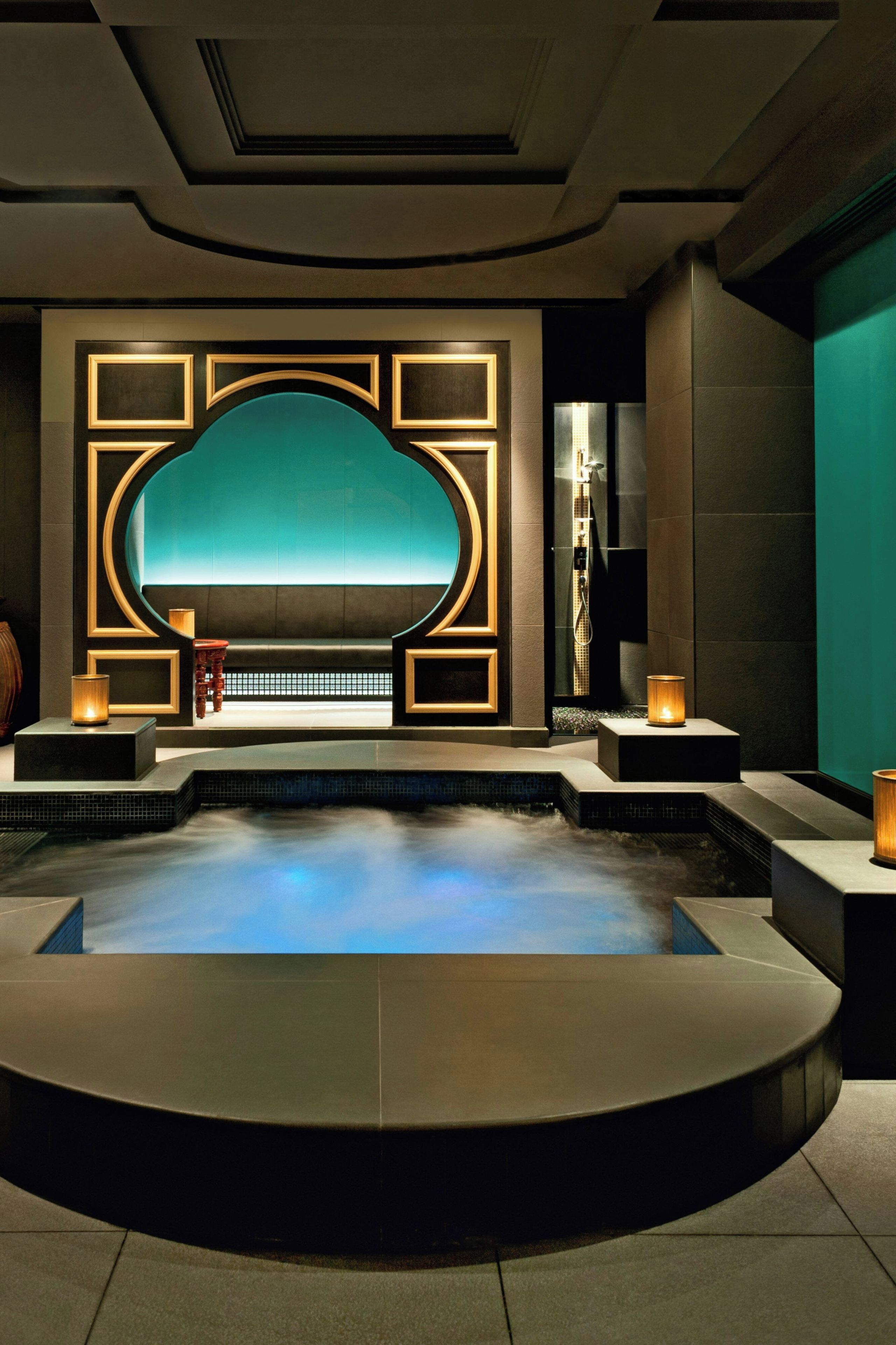 Uma área de spa moderna com piscina central, espaços de estar e uma grande parede com padrões geométricos.