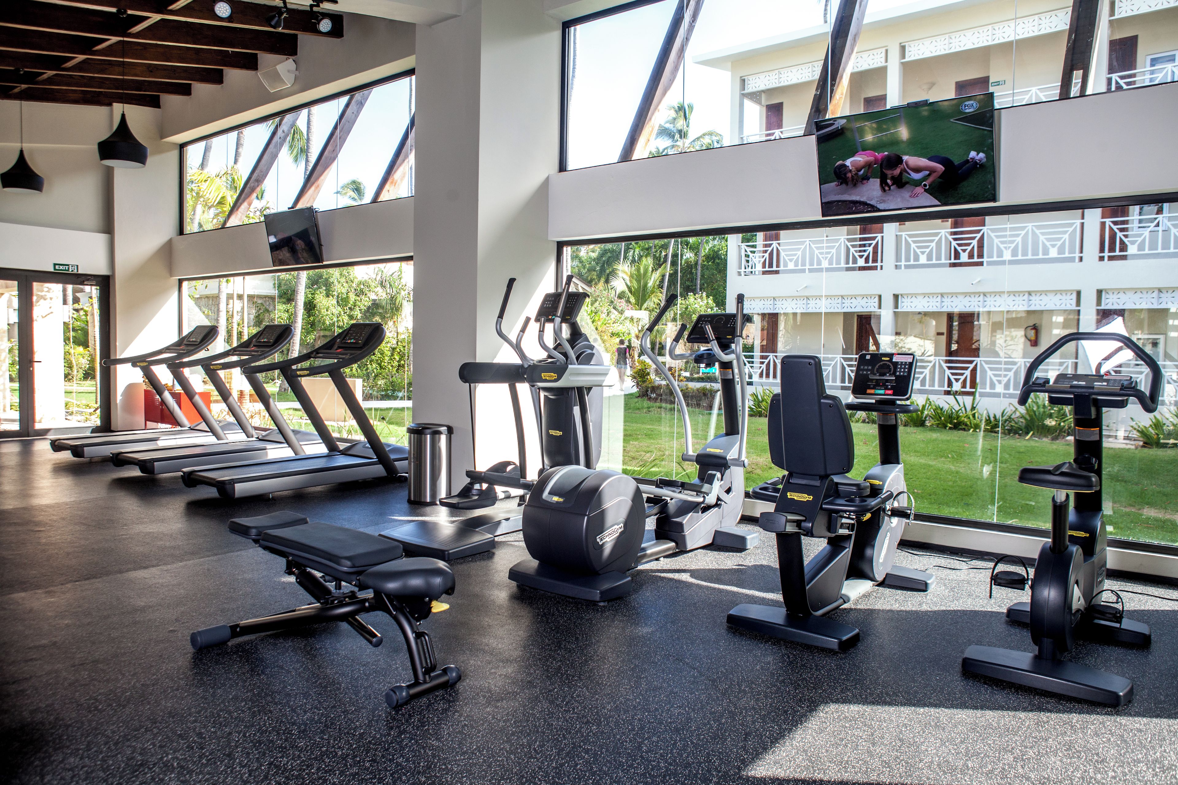 Academia com esteiras, elípticos e equipamentos de musculação.