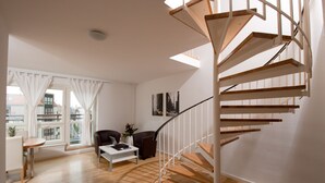 Uma sala de estar moderna com uma escada em espiral, piso de madeira, uma mesa de centro branca e vista da cidade através de grandes janelas.