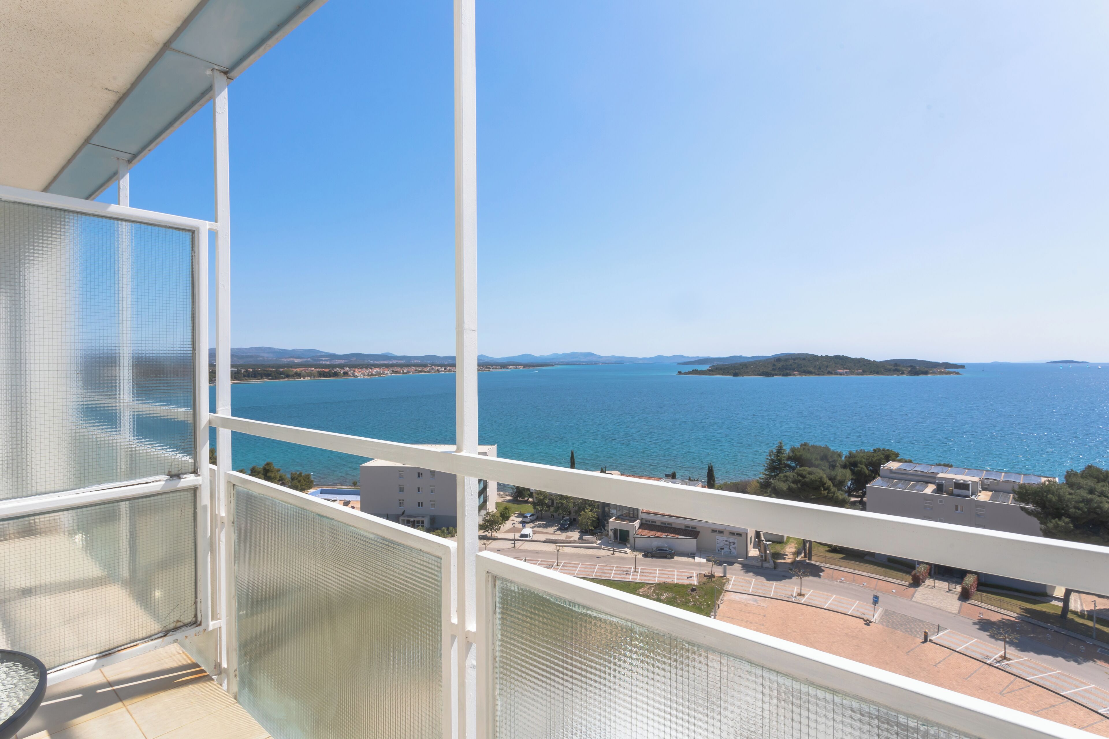 Varanda com vista para um corpo de água e terra distante.