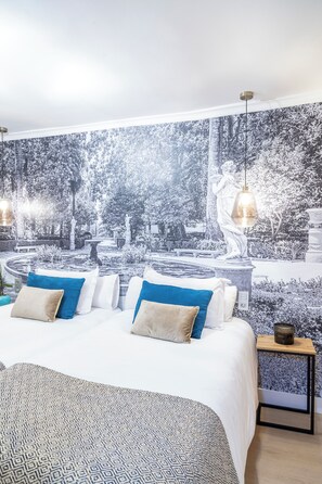 Quarto com cama grande, mesa de cabeceira e um mural de jardim na parede.