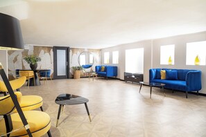 Uma sala de estar moderna com sofá, cadeiras, mesa e abajur.