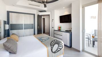 Quarto de hotel com cama, escrivaninha, televisão e vista para o exterior.