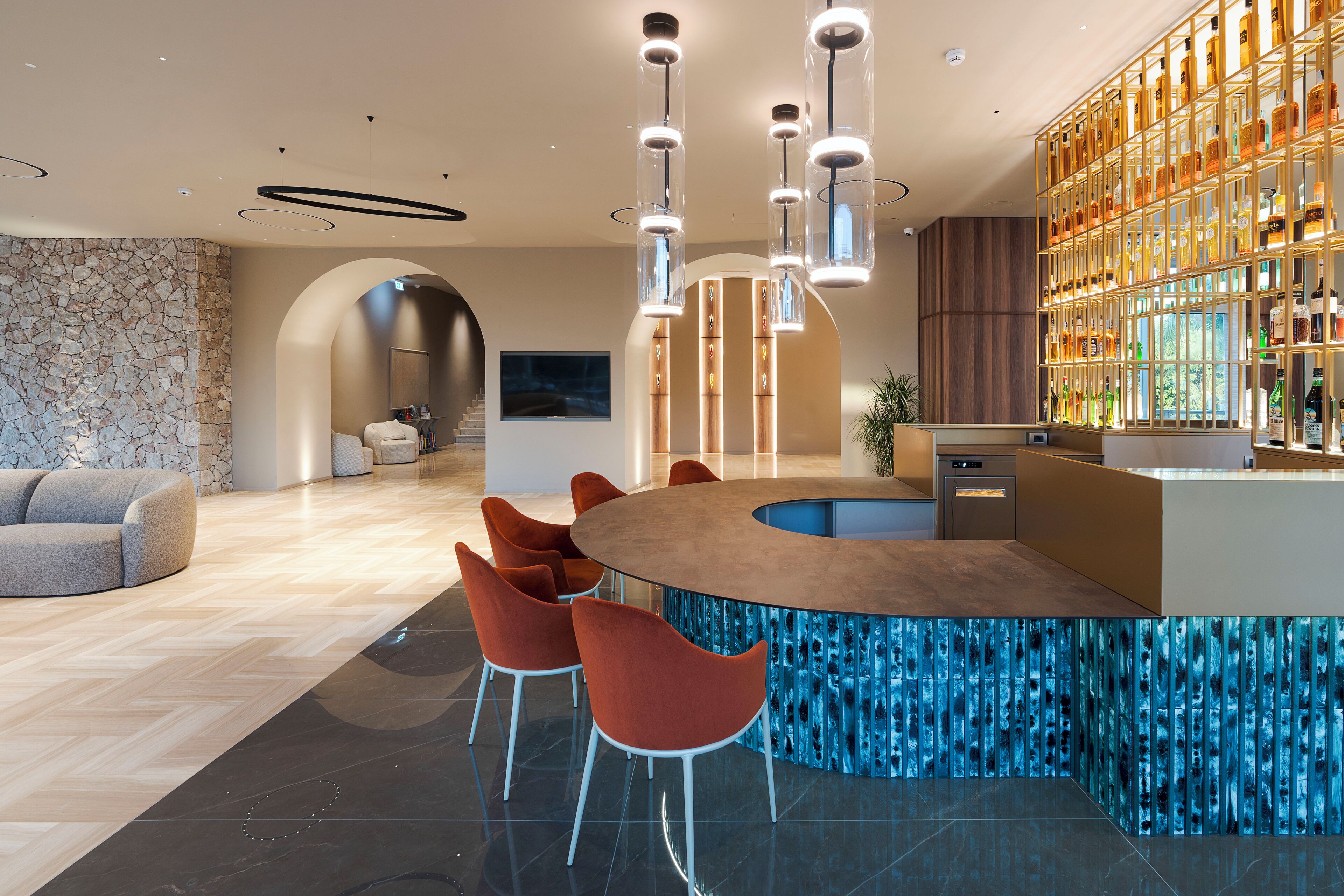 Uma área de bar moderna com ilha central, banquetas e adega.