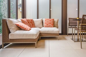 Uma sala de estar moderna com um sofá seccional, uma mesa de jantar e cadeiras.