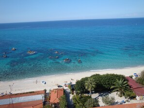 Praia particular, areia branca, espreguiçadeiras, guarda-sóis 