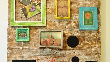 Paredes decoradas com diversos quadros e um vaso de flores.