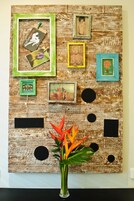 Paredes decoradas com diversos quadros e um vaso de flores.