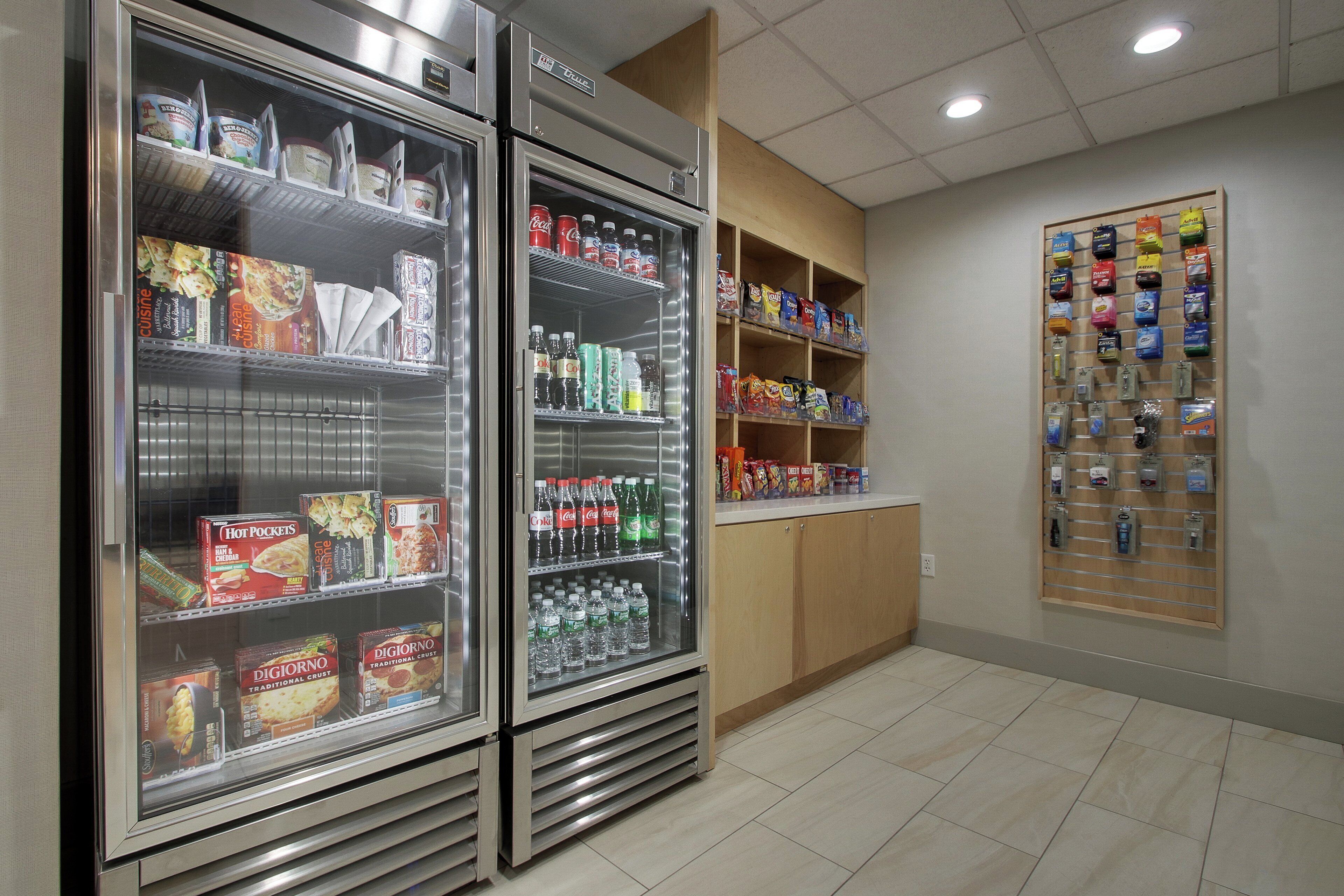Uma área de máquinas de venda automática com opções de lanches e bebidas, incluindo Pocket Hot e Coca-Cola.