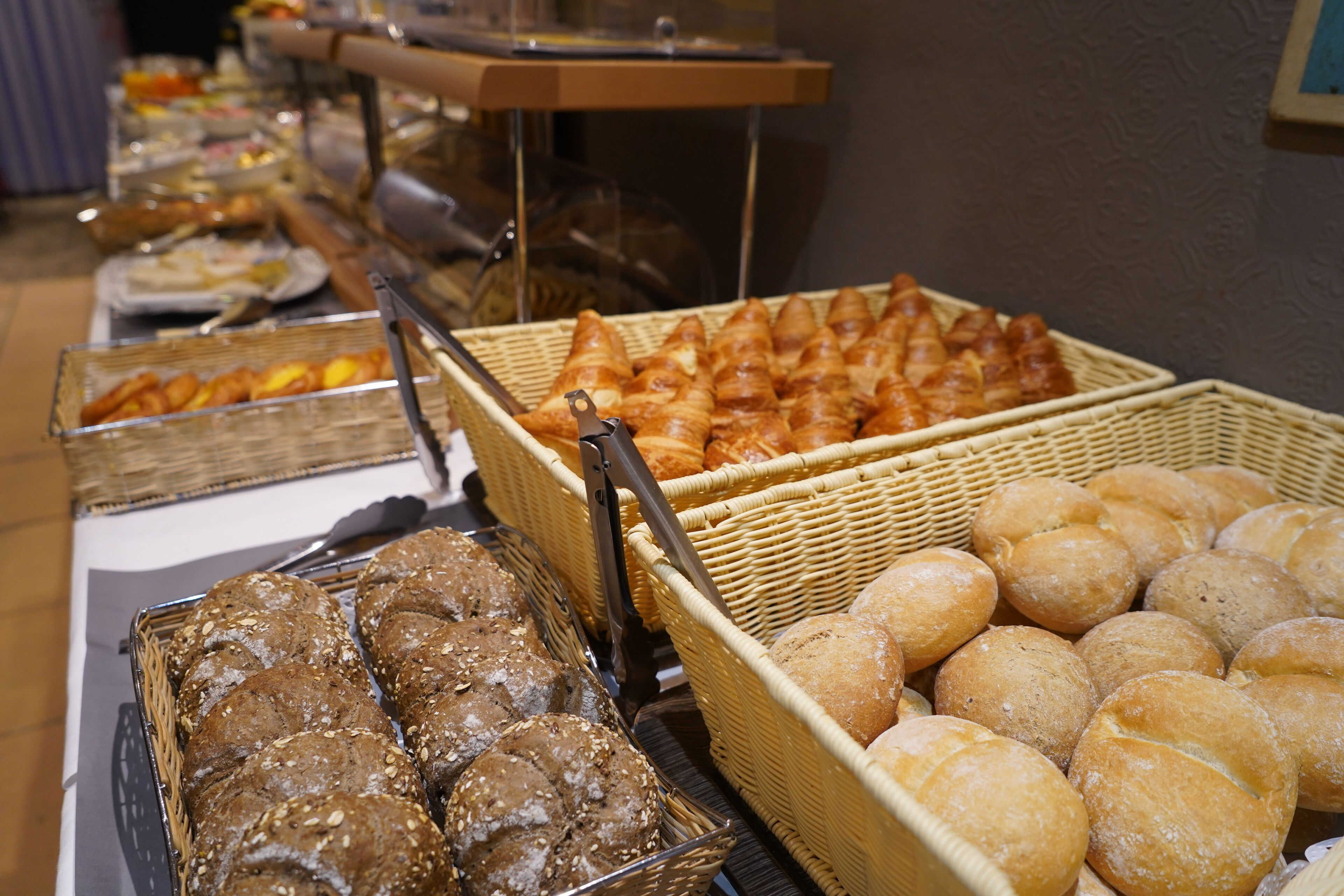 Buffet com pães e doces variados.