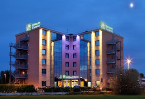 Um hotel Holiday Inn Express com fachada simétrica, várias varandas e uma entrada central.