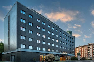 Um edifício de hotel moderno com fachada plana, várias janelas e uma placa indicando ser um hotel Marriott.