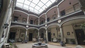 Um átrio amplo com uma fonte central, várias varandas e arquitetura clássica.