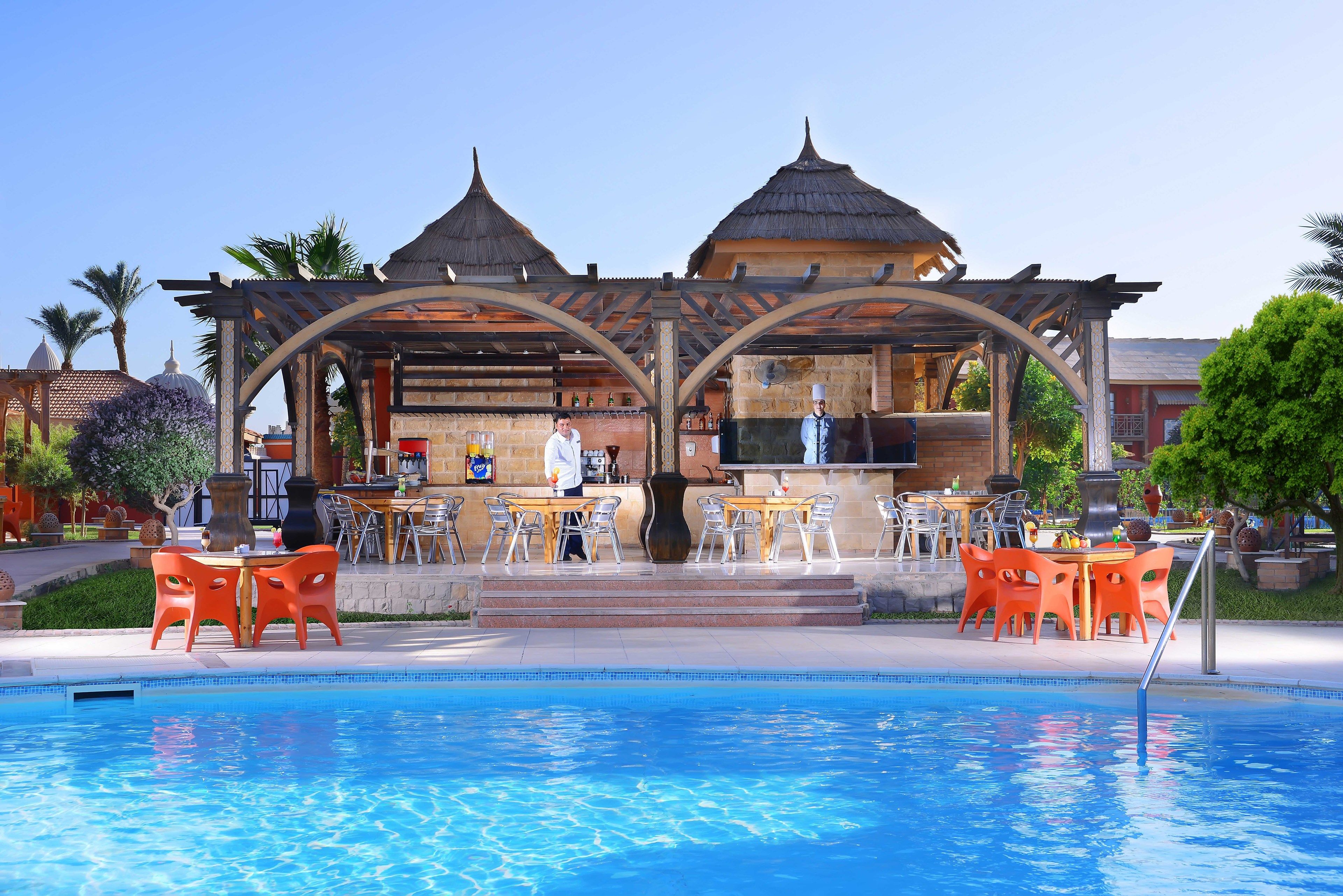 Uma área de piscina com assentos externos e um bar.