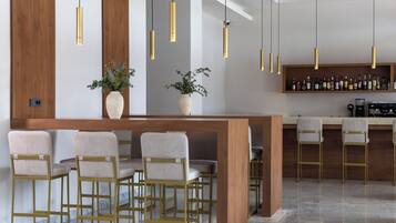Uma área de bar moderna com detalhes em madeira, banquetas, luminárias pendentes e um espaço para vinhos.