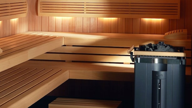 Uma sauna com bancos de madeira e painel de controle.