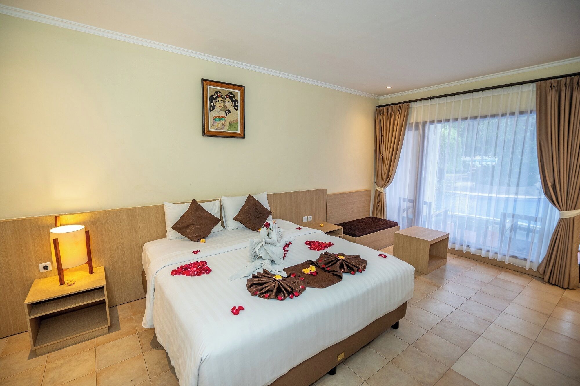 Quarto de hotel com cama, mesas de cabeceira, luminária, quadro na parede e janela com cortinas.