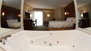 Quarto de hotel com uma banheira grande, uma escrivaninha, uma cadeira, uma cama e uma televisão.