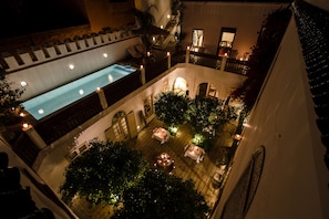 Um pátio com piscina, área de estar ao ar livre e escadaria.
