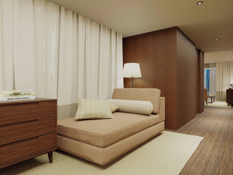 Quarto de hotel moderno com cama, mesa de cabeceira, luminária e guarda-roupa de madeira.
