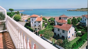 Uma cidade costeira com arquitetura tradicional, vista clara do mar e um calçadão.