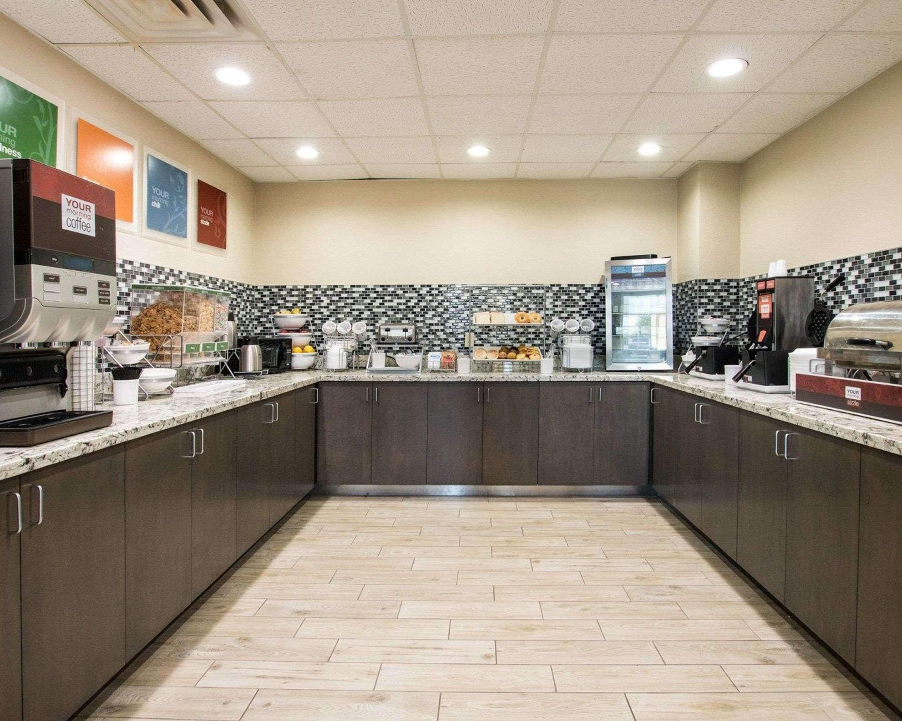 Uma cozinha moderna com espaço para café, geladeira e micro-ondas.