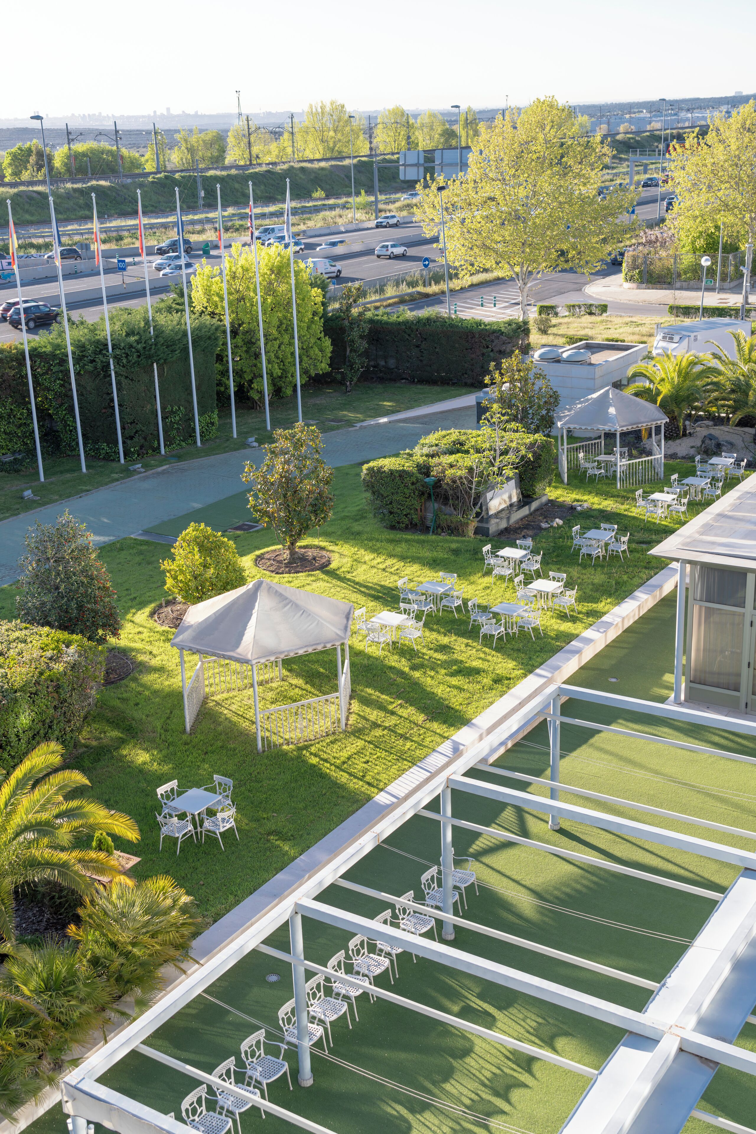 Jardim no terraço com área de estar ao ar livre e um gazebo.