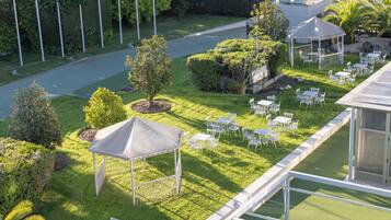 Jardim no terraço com área de estar ao ar livre e um gazebo.