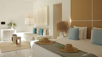 Quarto de hotel moderno com uma cama grande, um sofá, uma mesinha e um painel decorativo na parede.