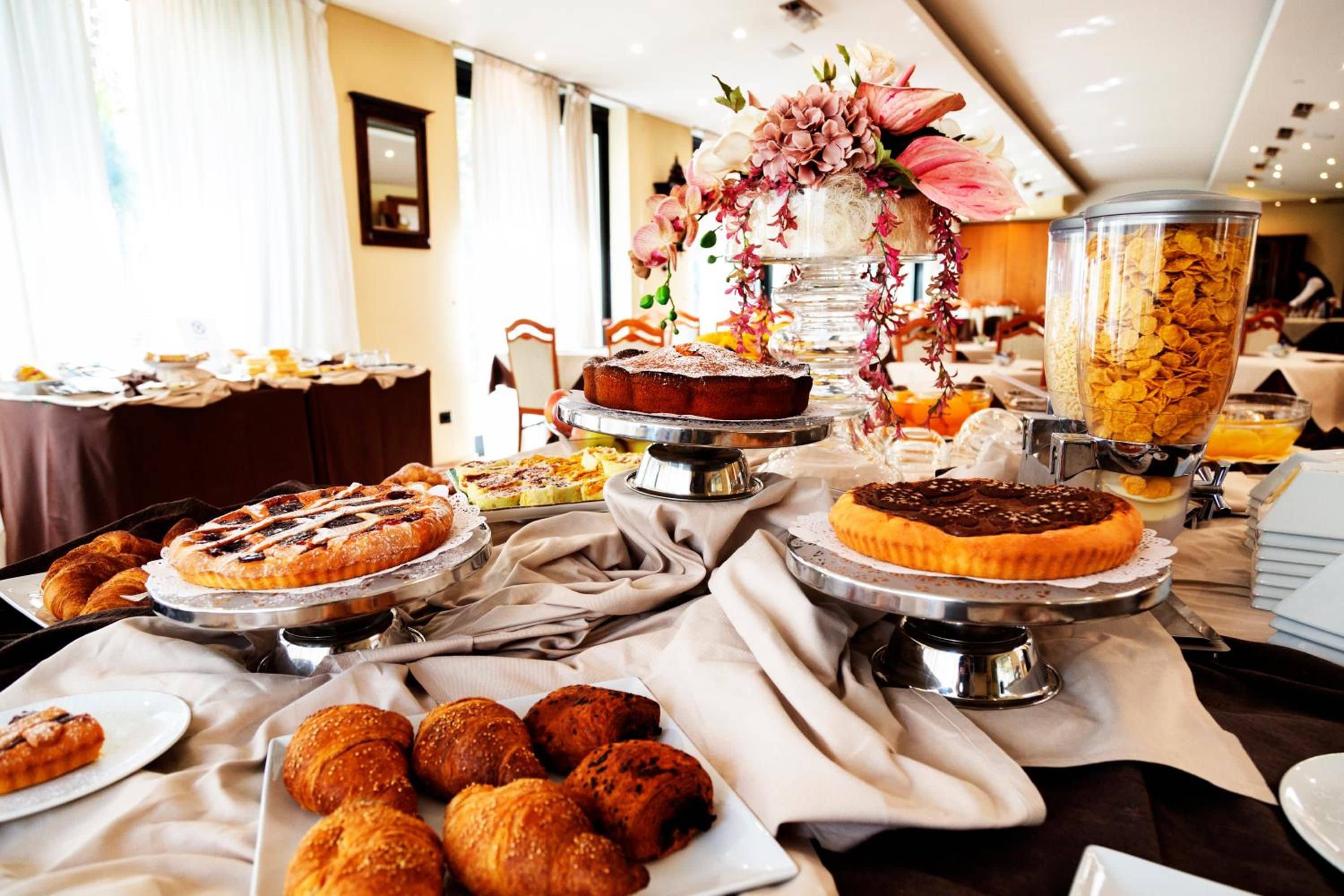 Mesa de buffet com diversos doces e uma cesta de frutas.