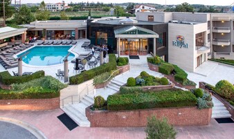 Um hotel com piscina, área de estar externa e um jardim bem cuidado.
