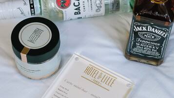 Uma garrafa de uísque Jack Daniel's Tennessee, um pote de caramelos e um cardápio sobre uma superfície branca.