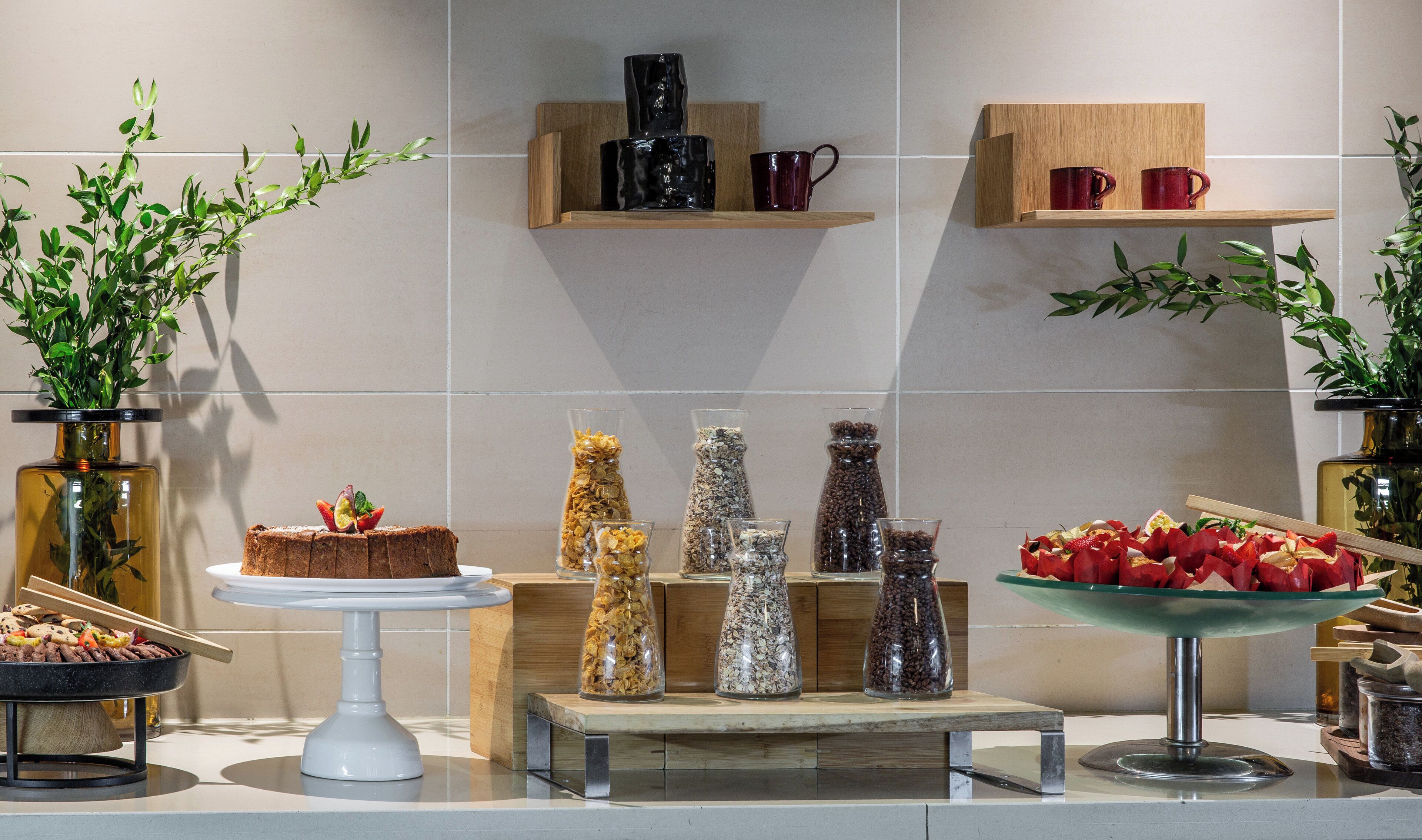 Uma mesa de buffet com diversos alimentos e copos disponíveis.