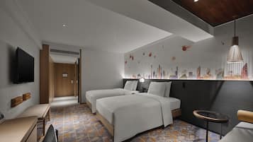 Quarto de hotel moderno com duas camas, uma escrivaninha, uma cadeira, uma TV e um mural com vista para a cidade.