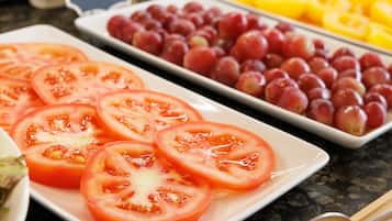 Exposição de tomates frescos e uvas em uma bancada.