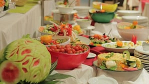 Uma mesa de buffet com diversos alimentos e um arranjo decorativo.