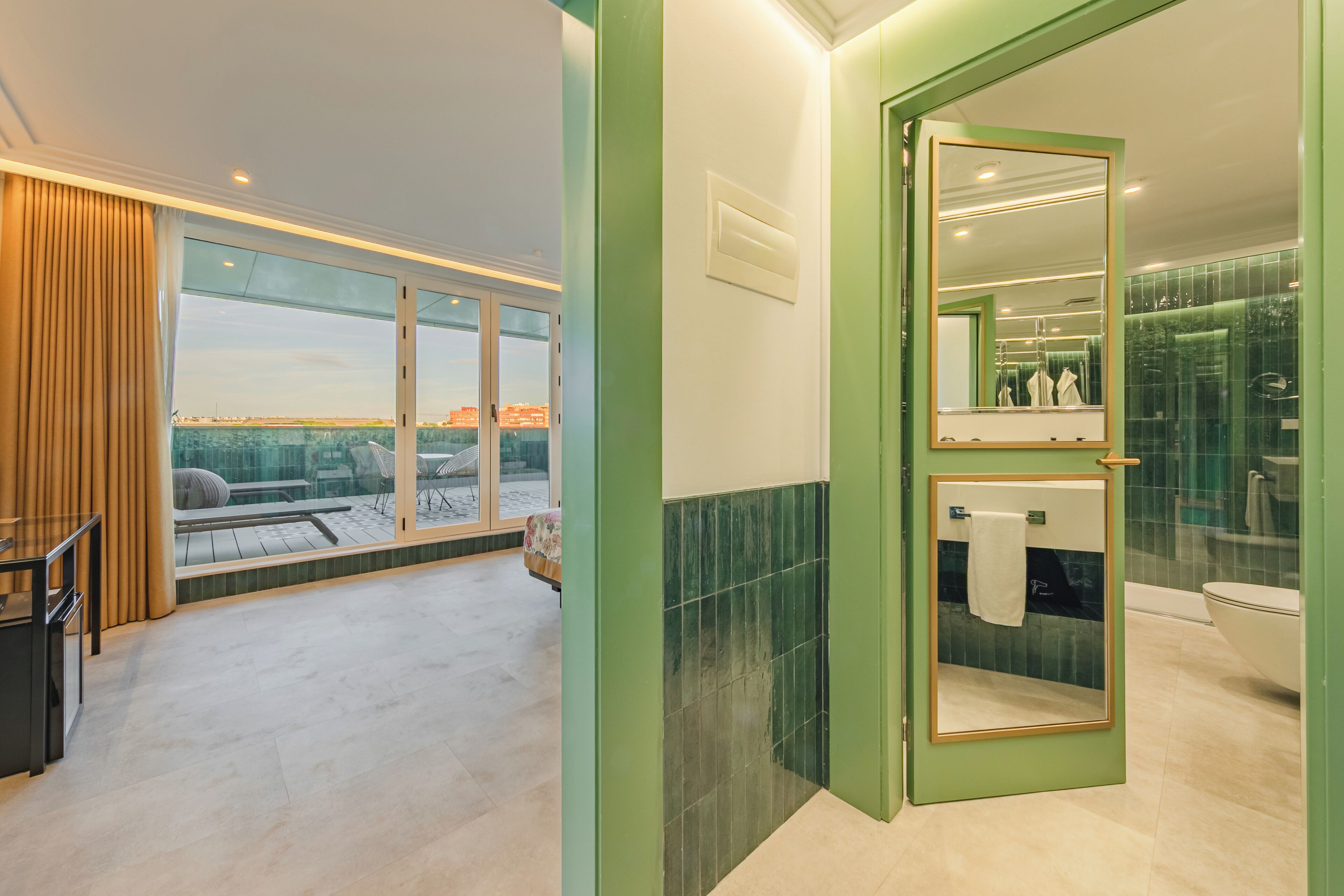 Um banheiro moderno com parede verde decorativa, um espelho grande e vista para o exterior.